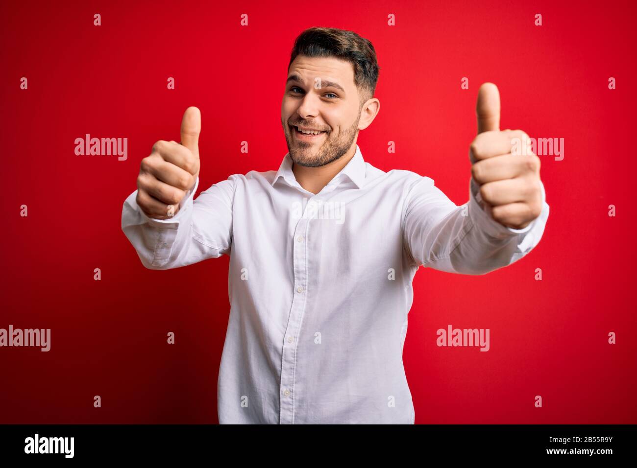 Young business man with blue eyes wearing elegant shirt standing over ...