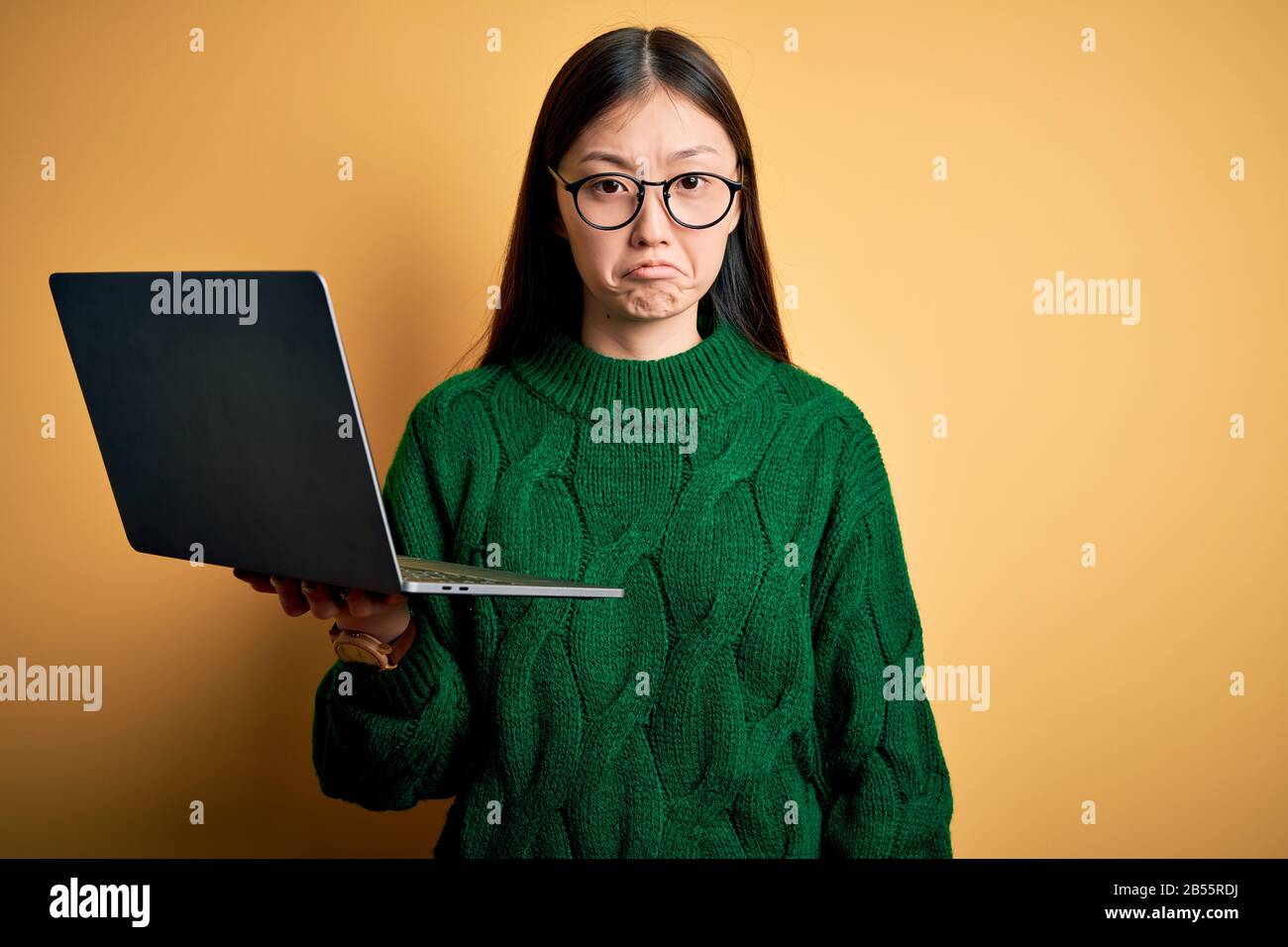 Young asian business woman wearing glasses and working using computer ...