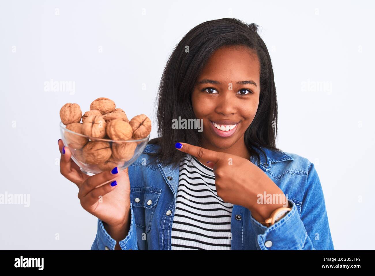 Young african american woman holding bunch of walnuts over isolated ...