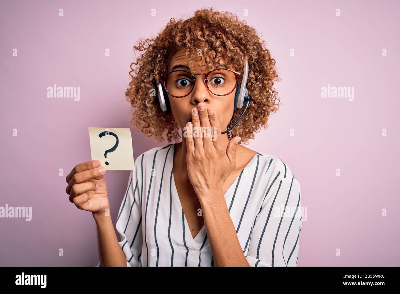 African american call center agent woman using headset holding paper ...