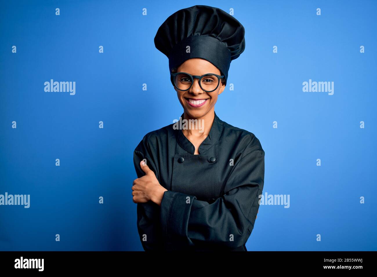 Young african american chef woman wearing cooker uniform and hat over ...