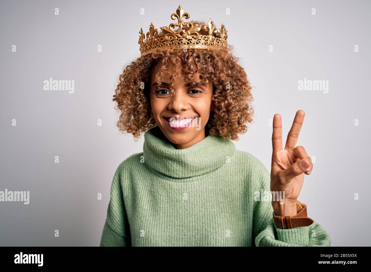 Young african american woman wearing golden crown of queen over ...