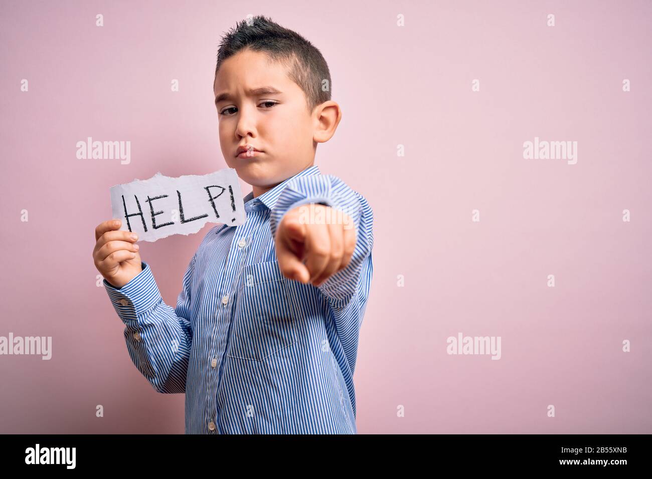 Young little boy kid holding paper sing with help message asking for ...