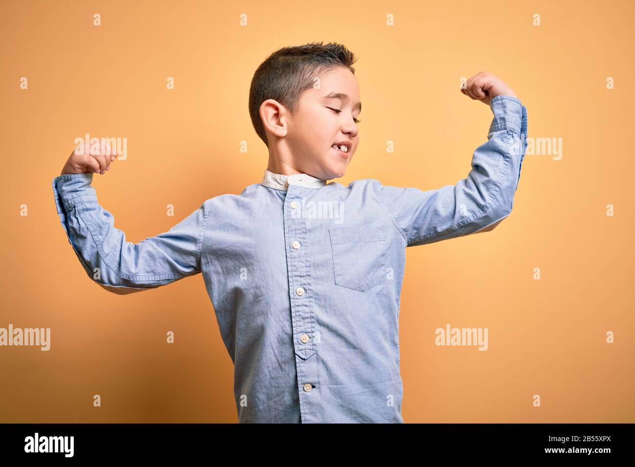 Young little boy kid wearing elegant shirt standing over yellow ...