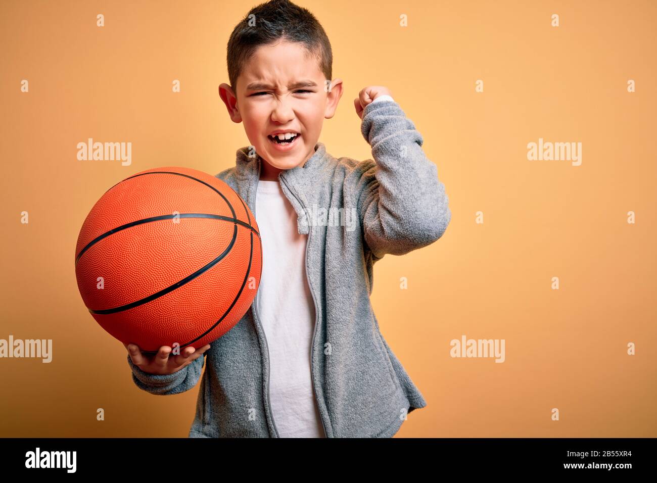 Young little boy kid playing with basketball game ball over isolated ...