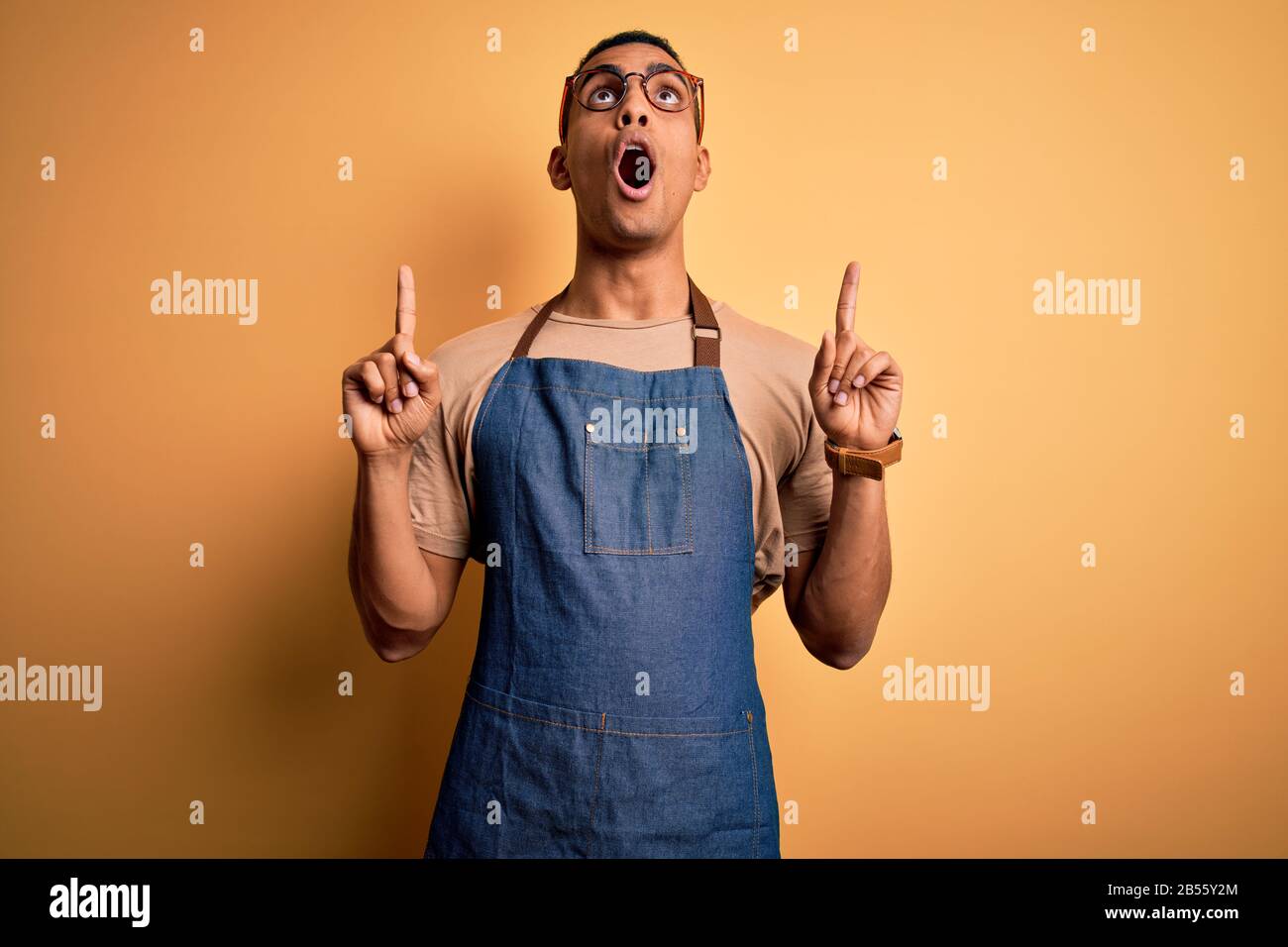 Young handsome african american shopkeeper man wearing apron over ...
