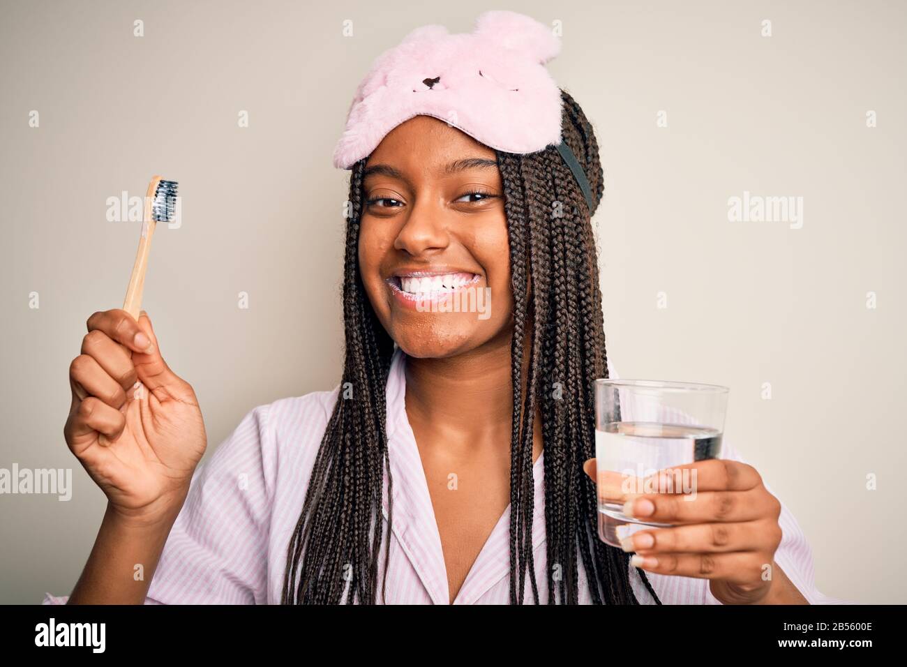 Young beautiful african american woman wearing pajama and sleep mask ...
