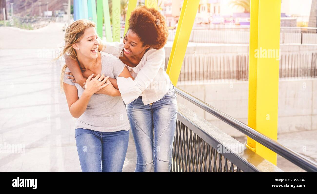 Happy women friends laughing and walking on colorful bridge - Young ...