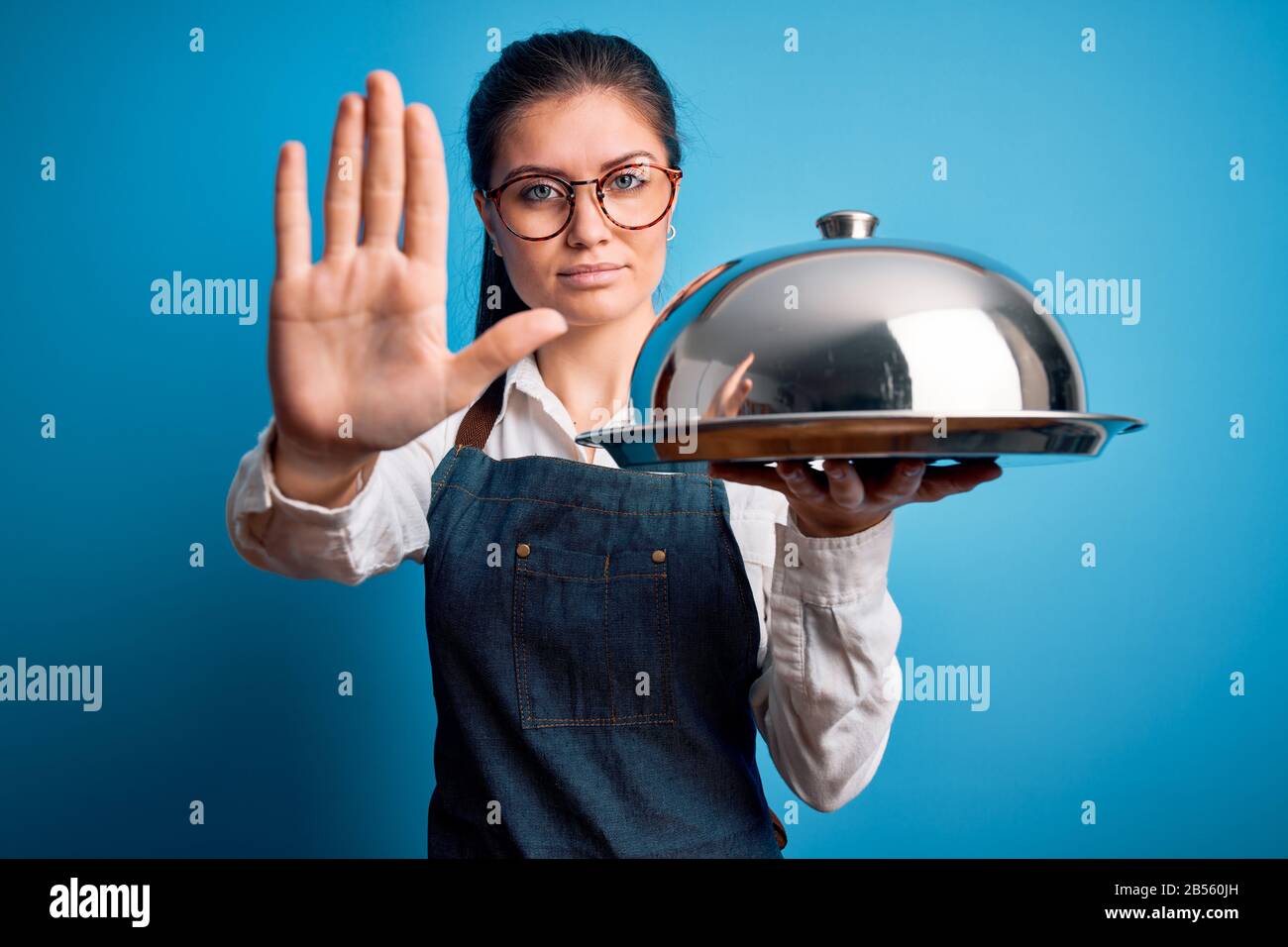 Young beautiful waitress woman with blue eyes holding tray with dome ...