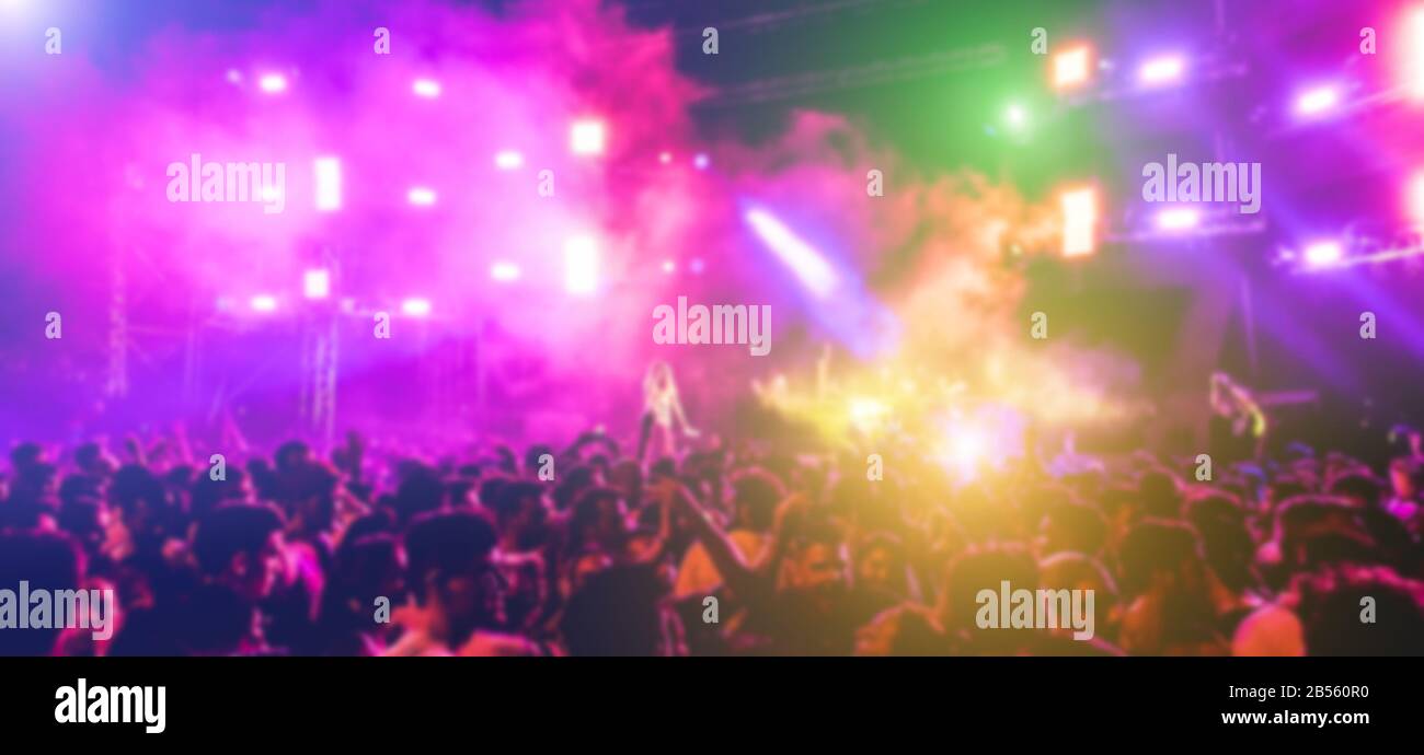 Blurred people dancing and having fun in summer festival concert ...