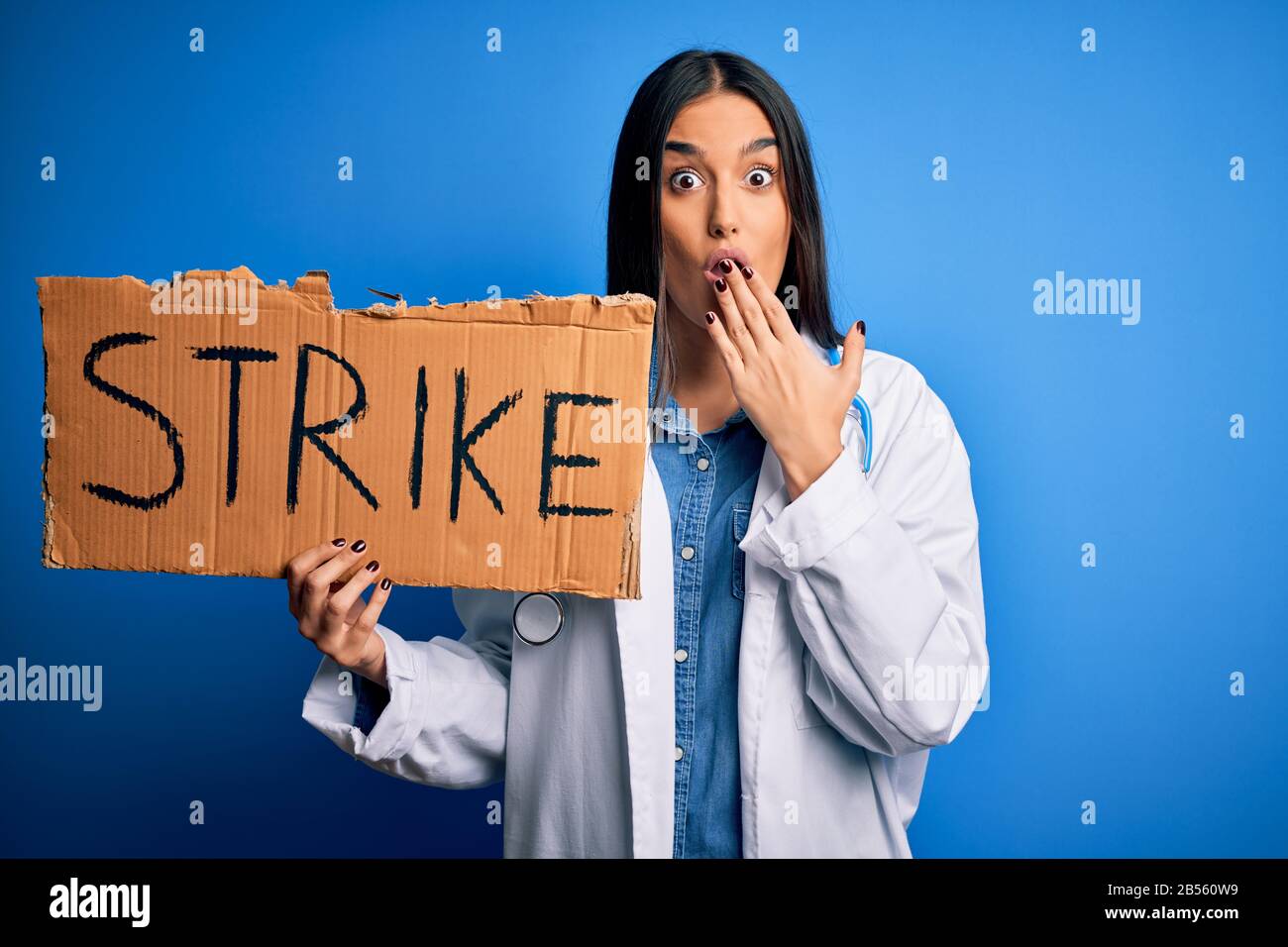 Young doctor woman wearing stethoscope holding cardboard banner ...