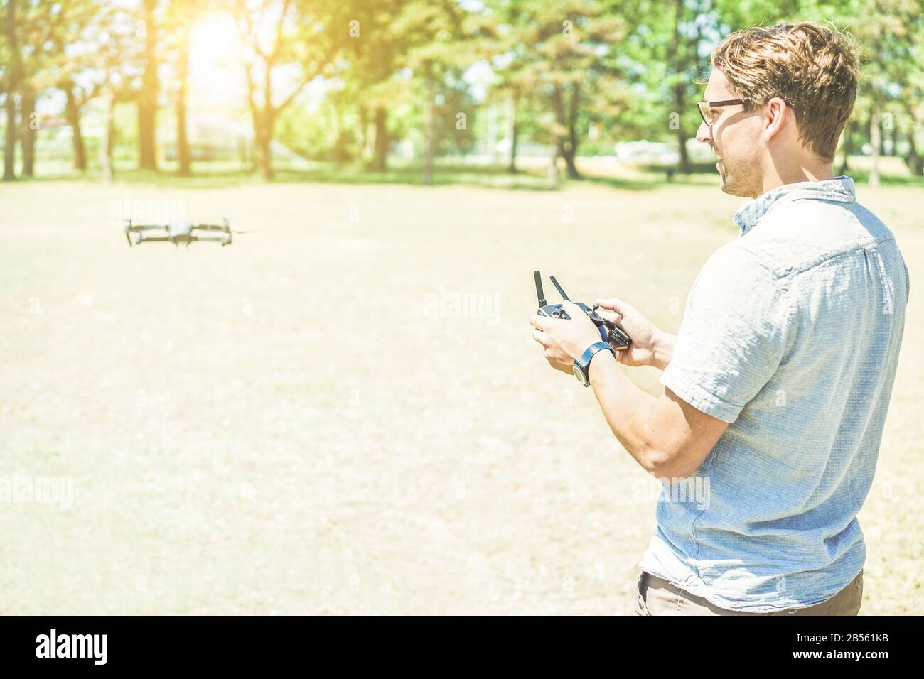 Young cheerful man using a drone with remote controller - Blond trendy ...