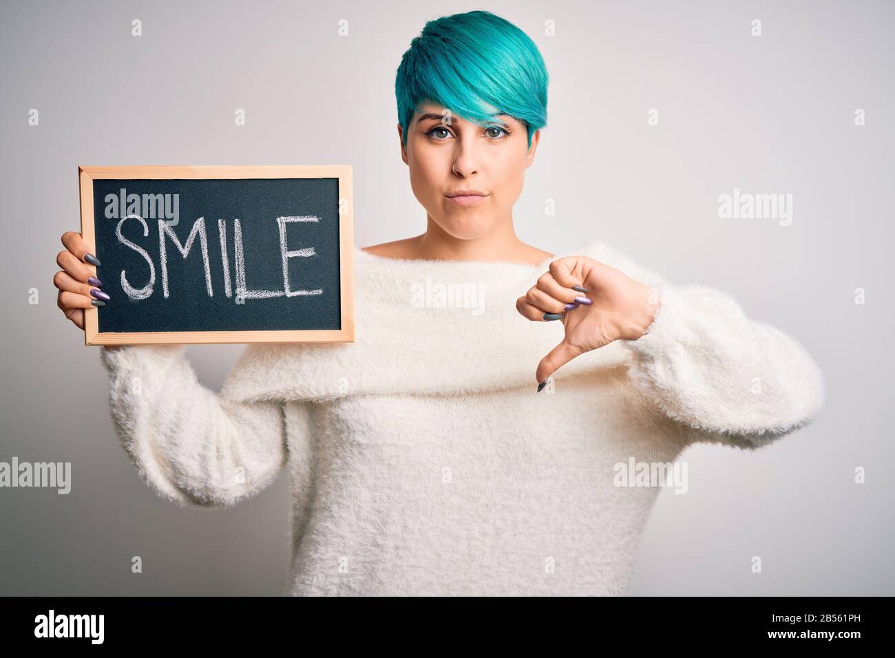 Young woman with blue fashion hair holding blackboard with smile ...