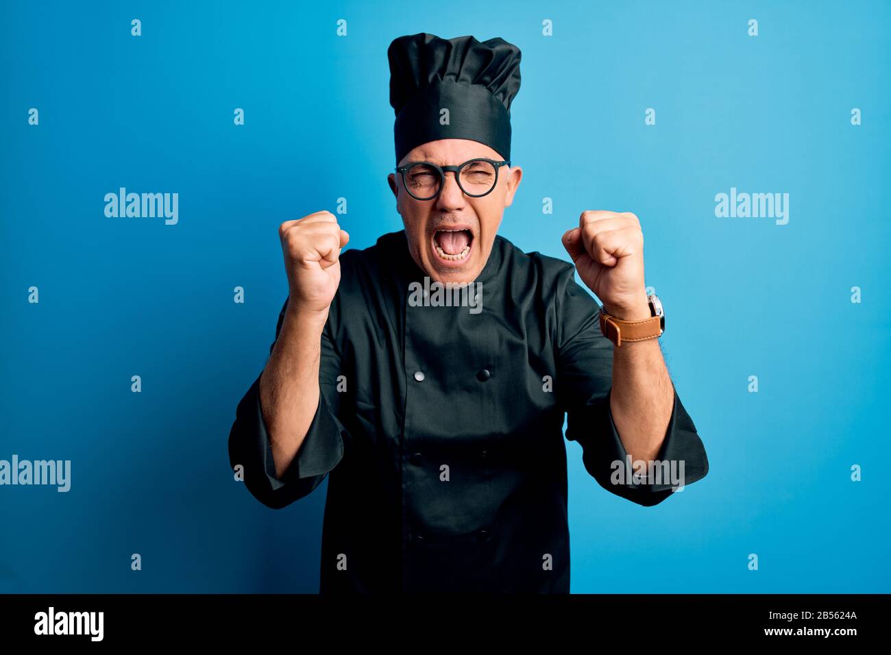 Middle age handsome grey-haired chef man wearing cooker uniform and hat ...