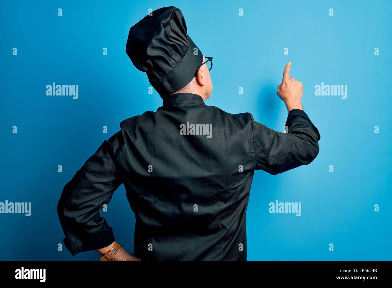Middle age handsome grey-haired chef man wearing cooker uniform and hat ...