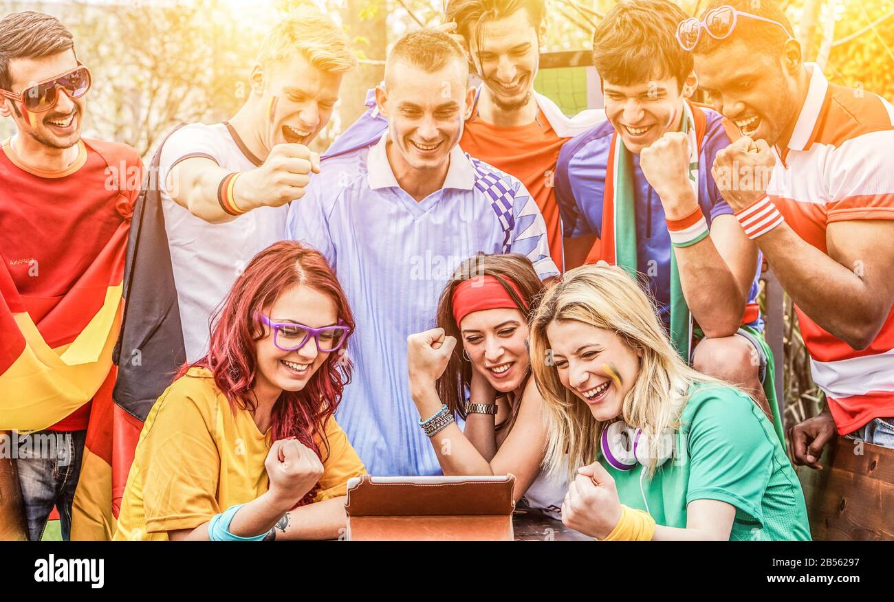 Happy sport friends fans watching football match on tablet outdoor ...