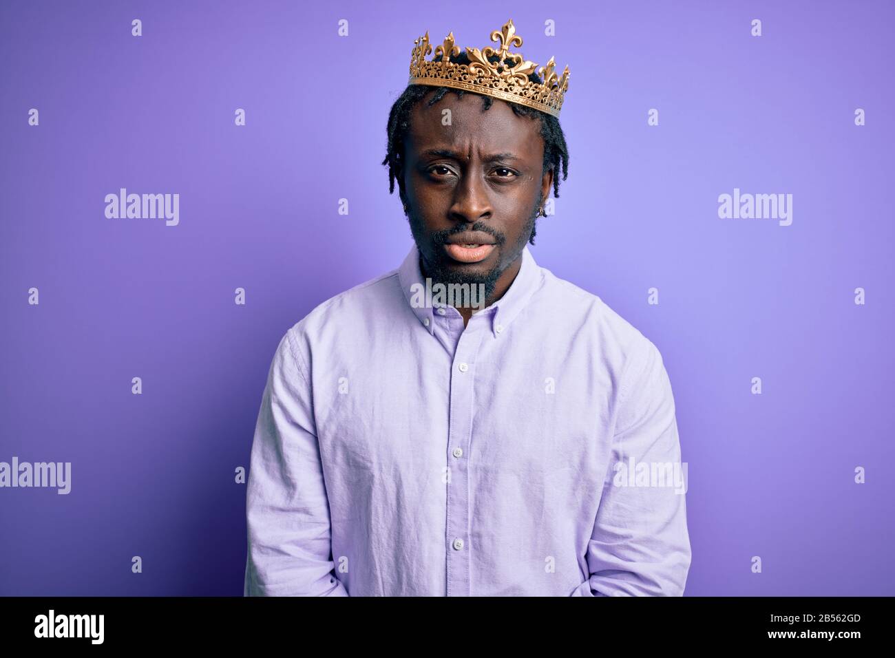 Young african american man wearing golden crown of king over isolated ...