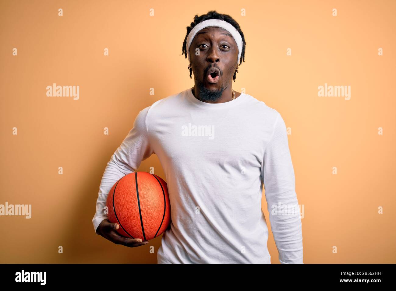 Young african american sportsman doing sport holding basketball ball ...