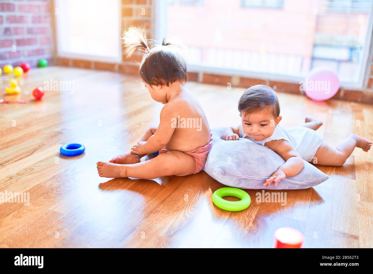Beautiful infant happy girls playing together at home kindergarten ...