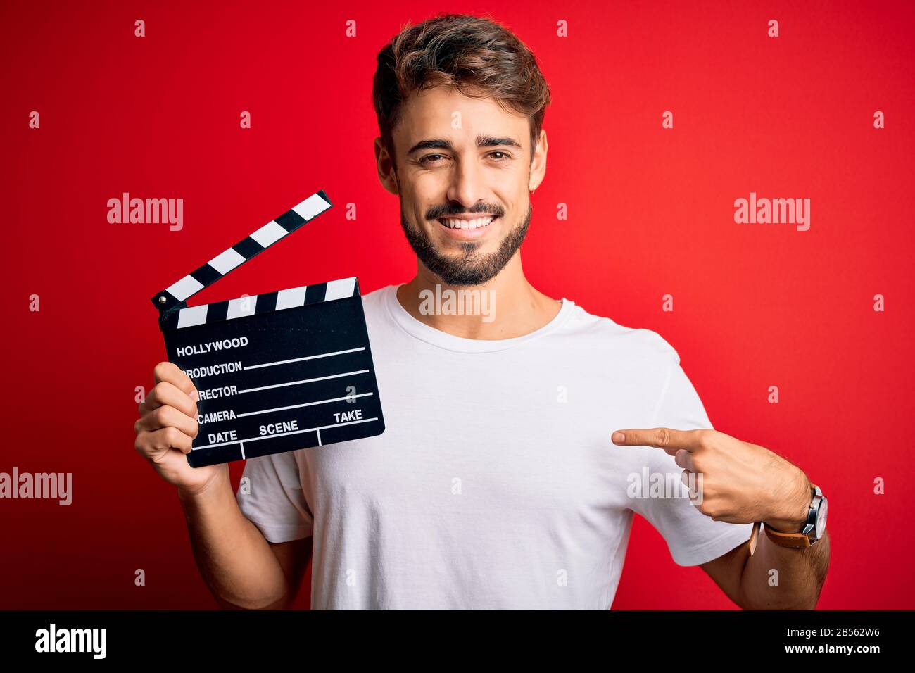 Young director man with beard making movie using clapboard over ...