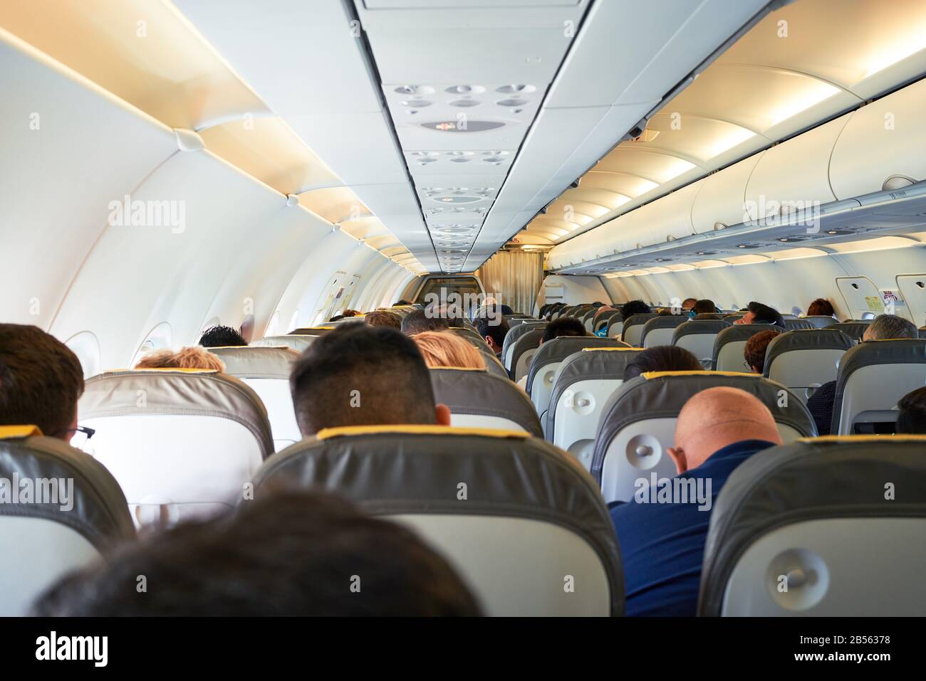 Passengers and crew sitting on airplane seats, view of the passengers ...