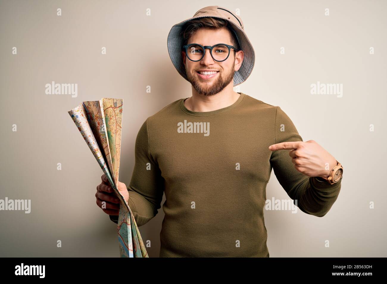 Young blond explorer man with beard and blue eyes wearing glasses and ...