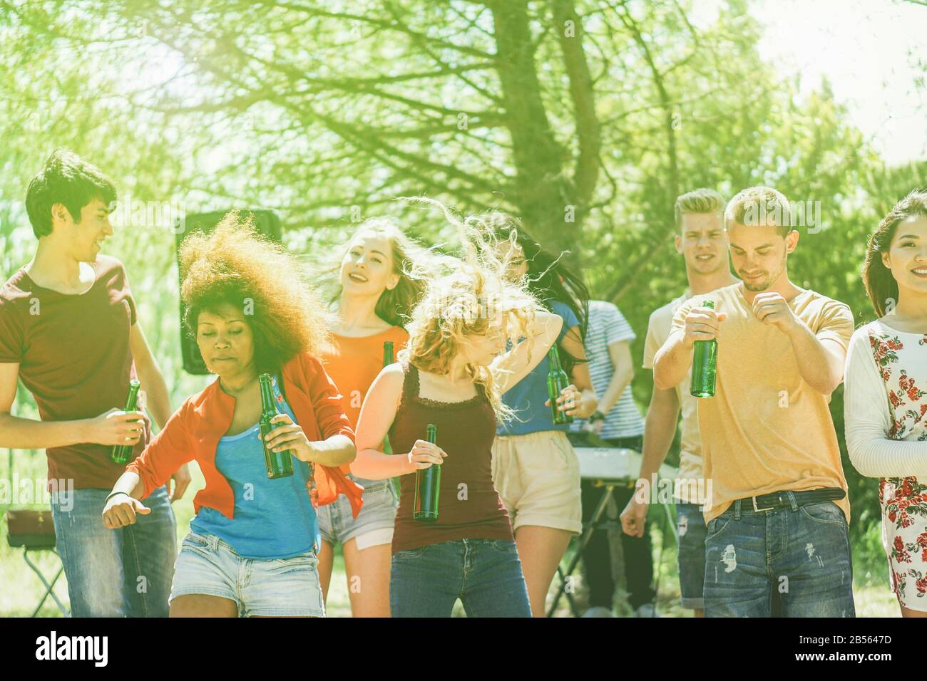 Multiracial young people dancing in forest party in summer time ...