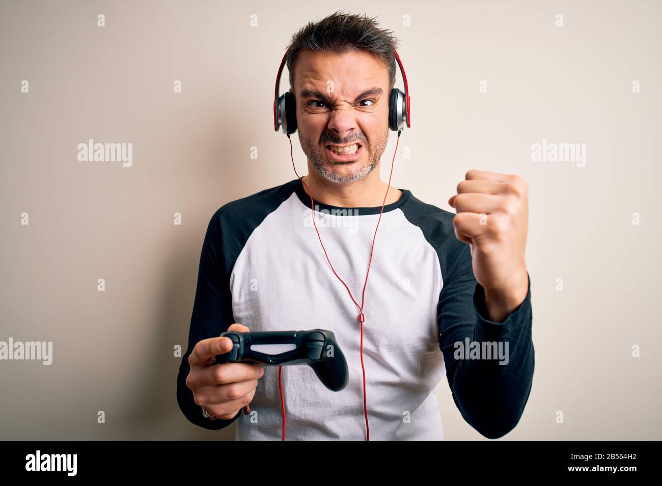 Young handsome gamer man playing video game using joystick and ...