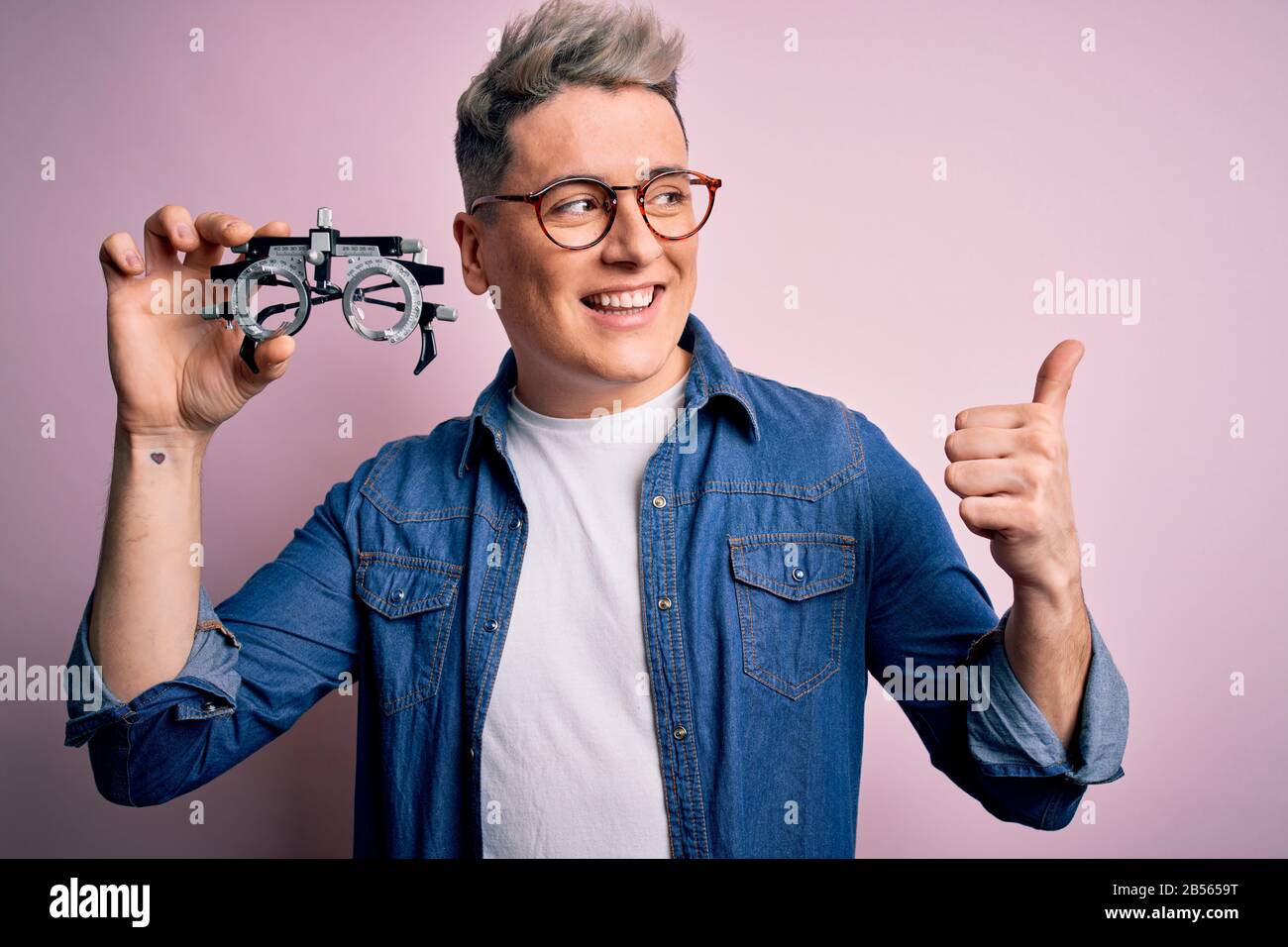 Young modern optical optomestrist man holding optometrical glasses over ...