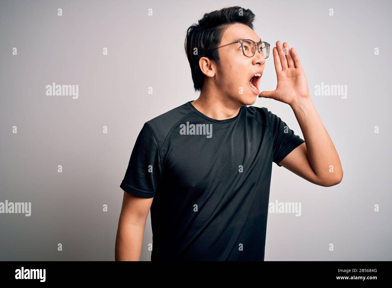 Young handsome chinese man wearing black t-shirt and glasses over white ...