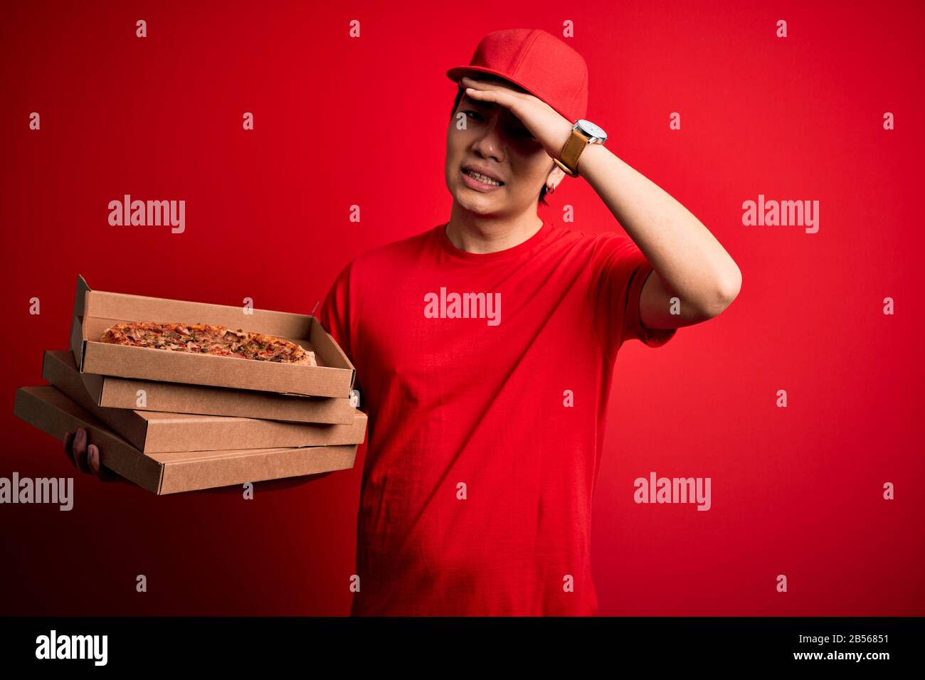 Young handsome chinese delivery man holding deliver boxes with Italian ...