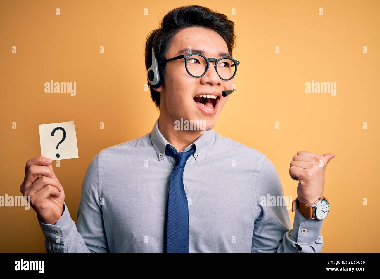 Young handsome chinese call center agent man holding paper with ...
