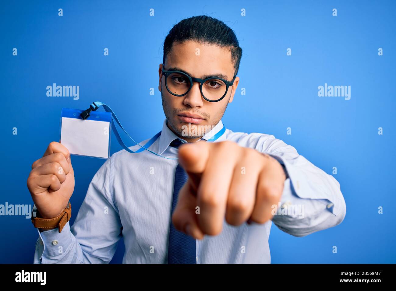 Young brazilian call center agent man holding id identification card ...