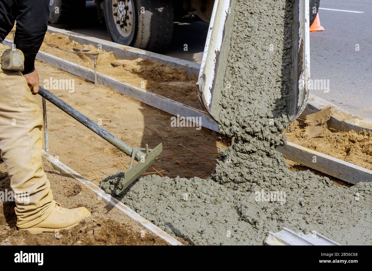 Concrete being poured from a mixer truck into a concrete with sidewalk ...