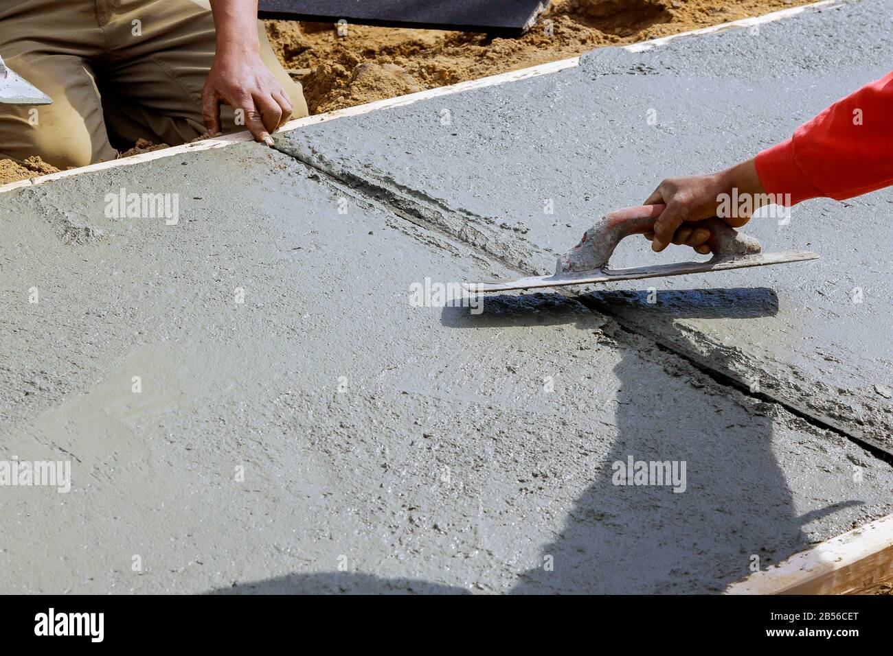 Construction workers laying concrete mixer with concrete mixer in the ...