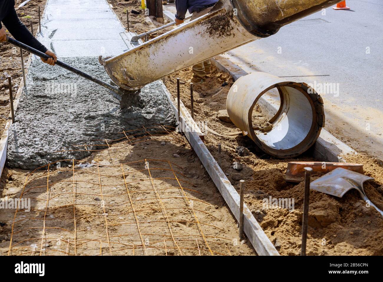 Mixer truck pouring cement concrete casting on reinforcing metal bars ...