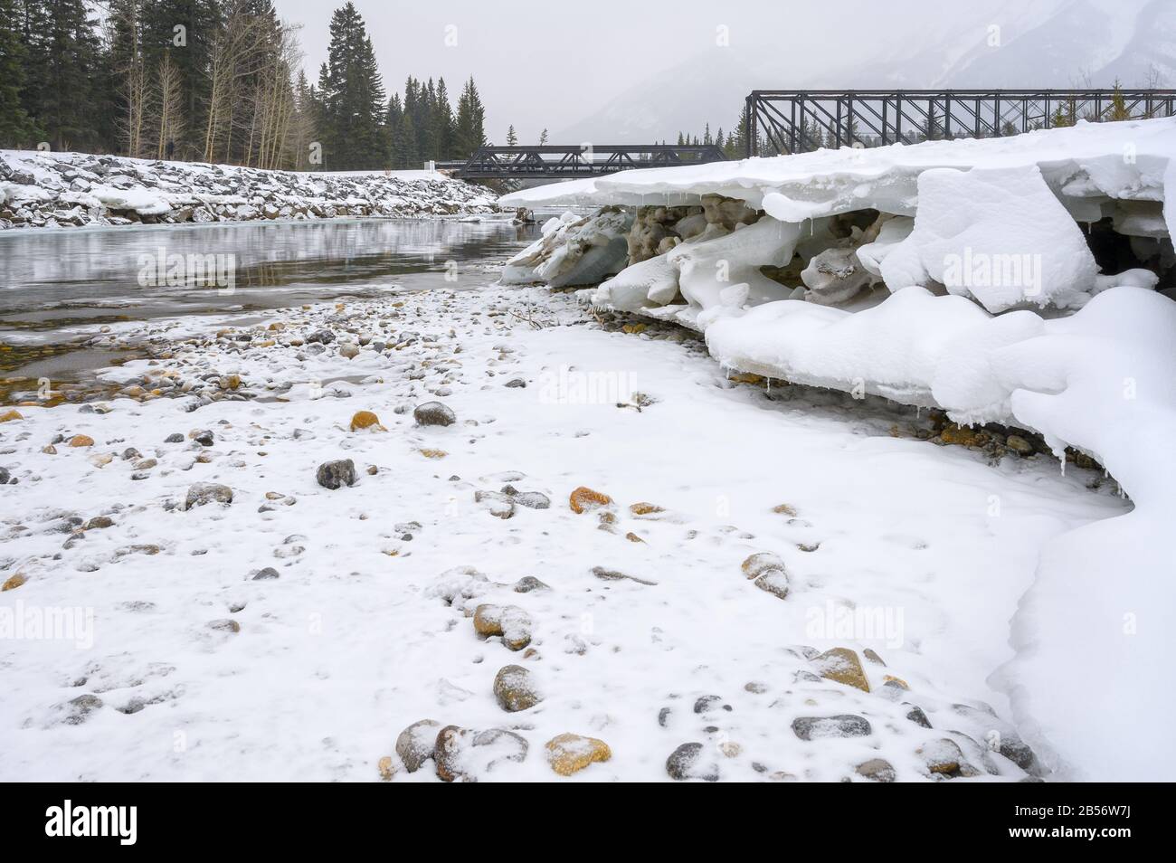 Snowy day at Engine Bridge pedestrian crossing over the Bow River in ...