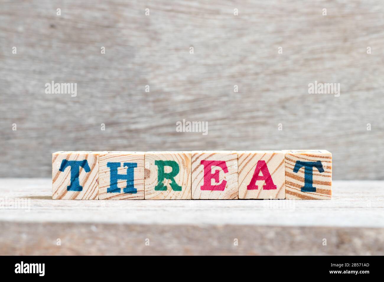 Letter block in word threat on wood background Stock Photo - Alamy