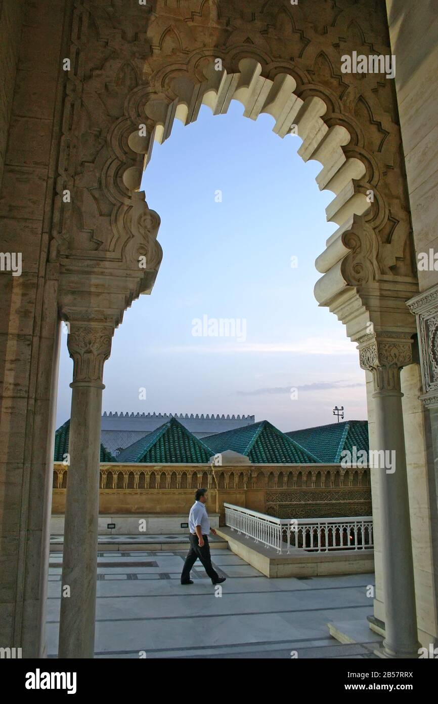 A man walks past an Islamic-style arch of the Mausoleum of Mohammed V ...