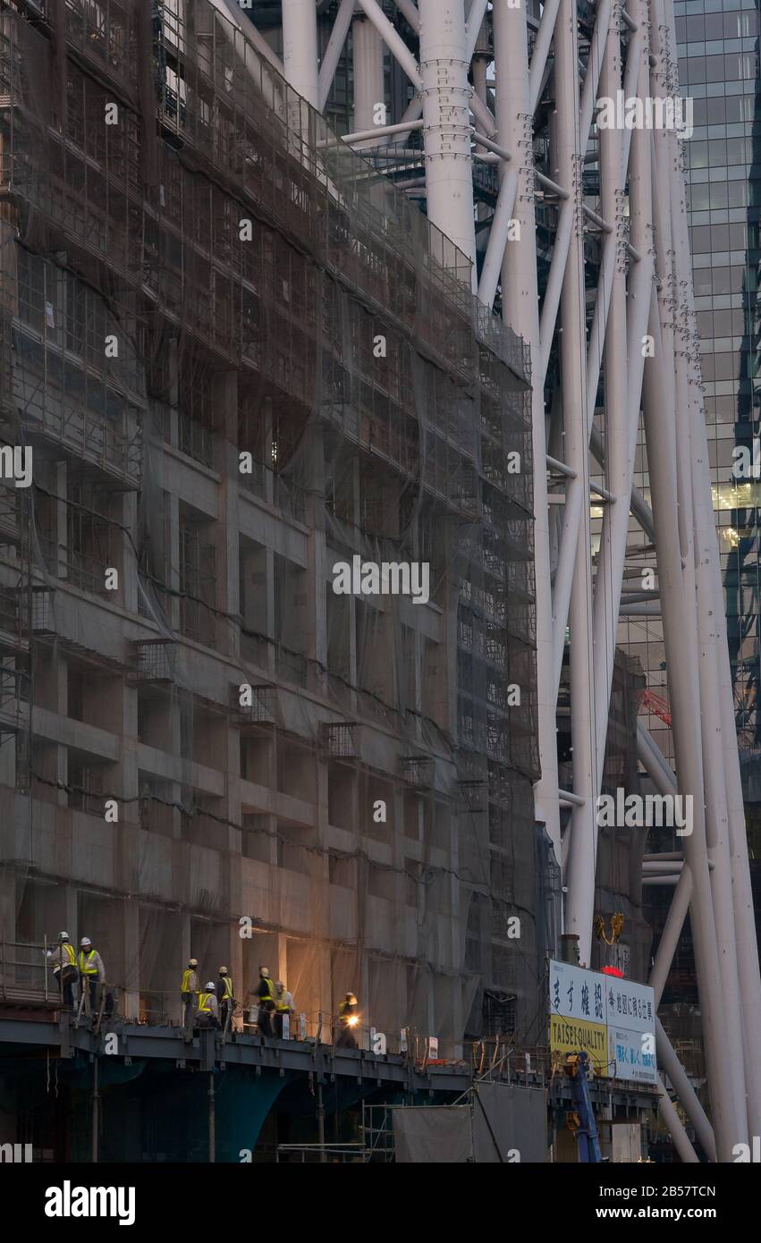 Construction workers on a half finished building during construction of ...