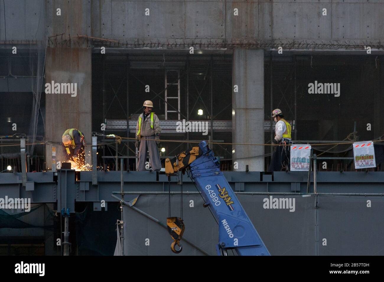 Construction workers on a half finished building during construction of ...