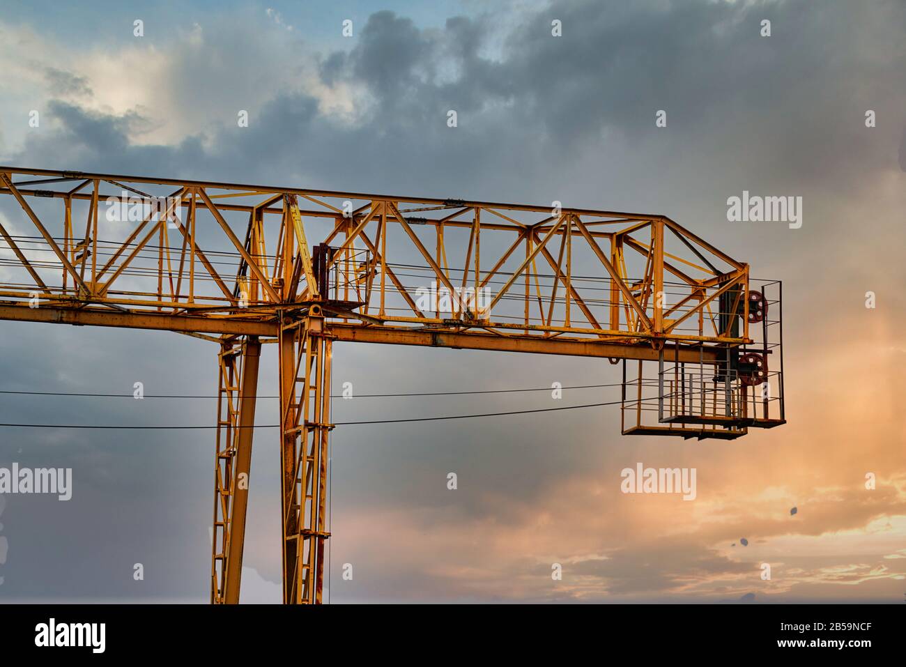 Industrial construction cranes and building silhouettes over sun at ...