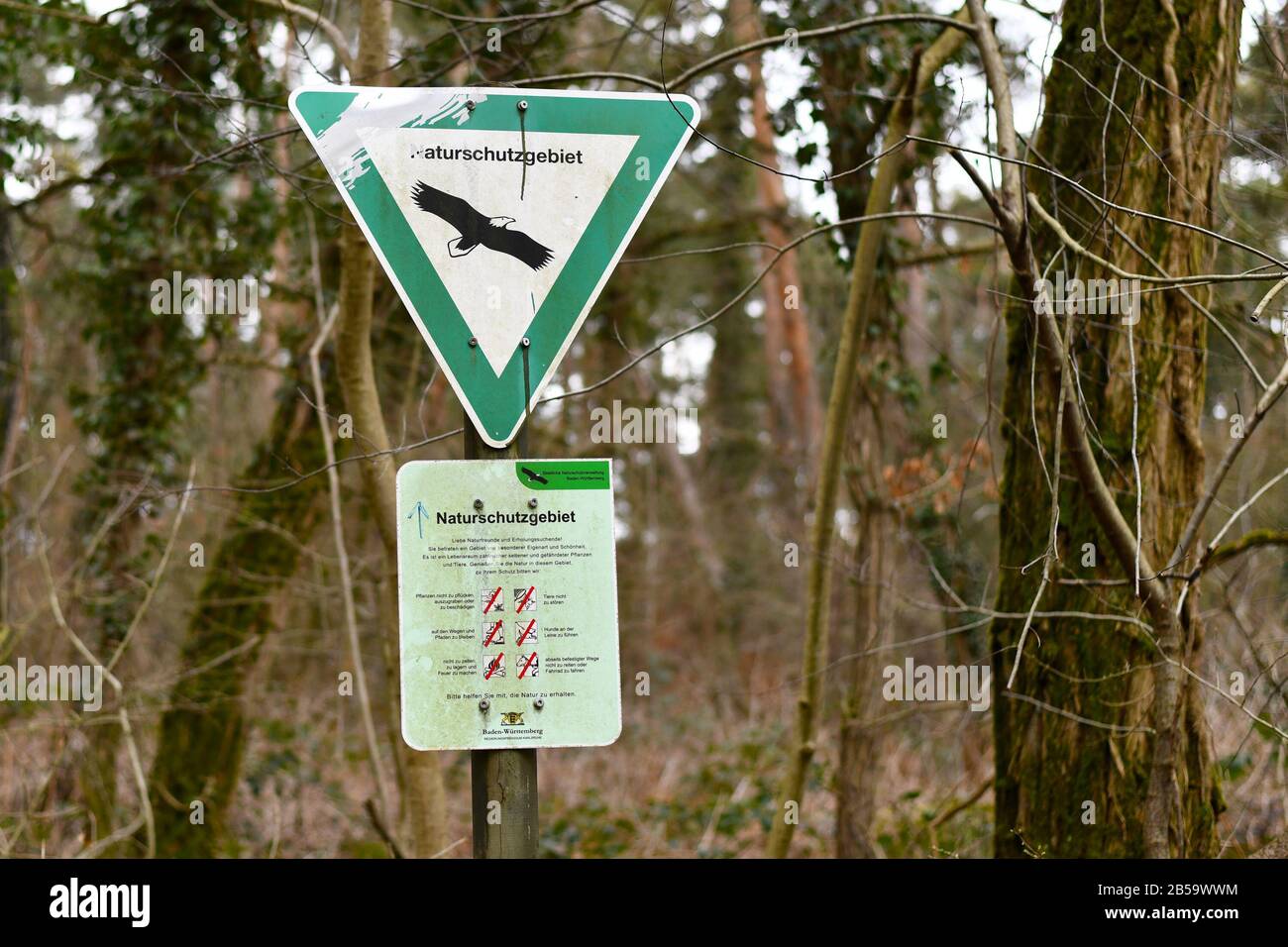 Green triangular sign with eagle and sign with behavior rules for ...