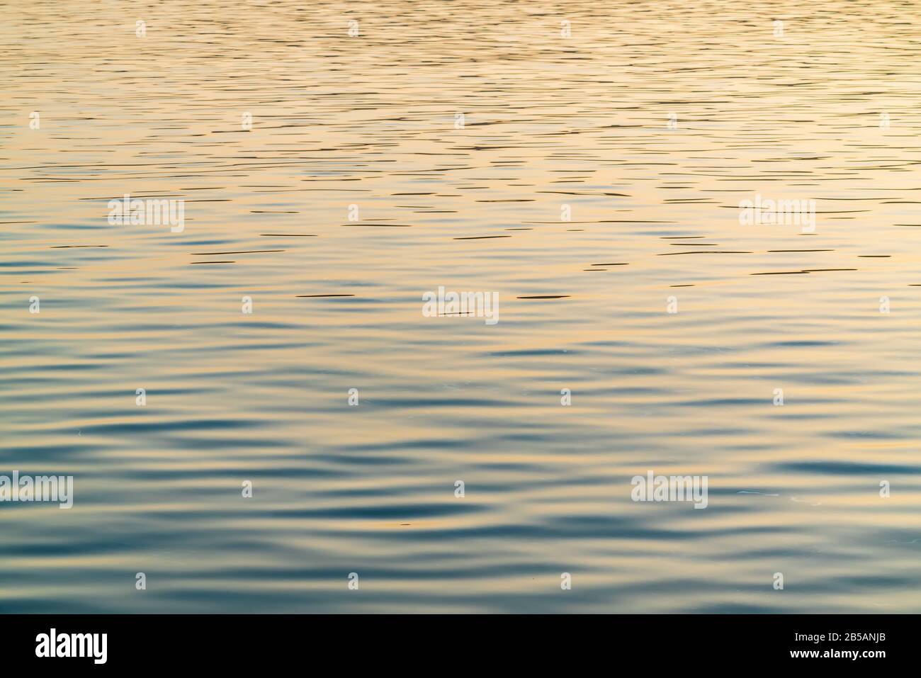 Sea surface with waves in sunset colors Stock Photo - Alamy