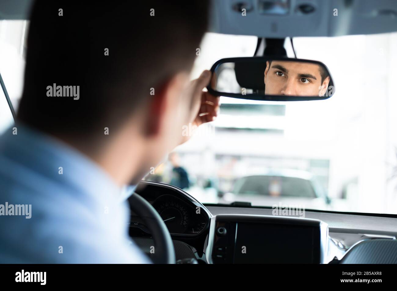 Guy Checking Mirrors Sitting In Driver's Seat In Dealership Store Stock ...