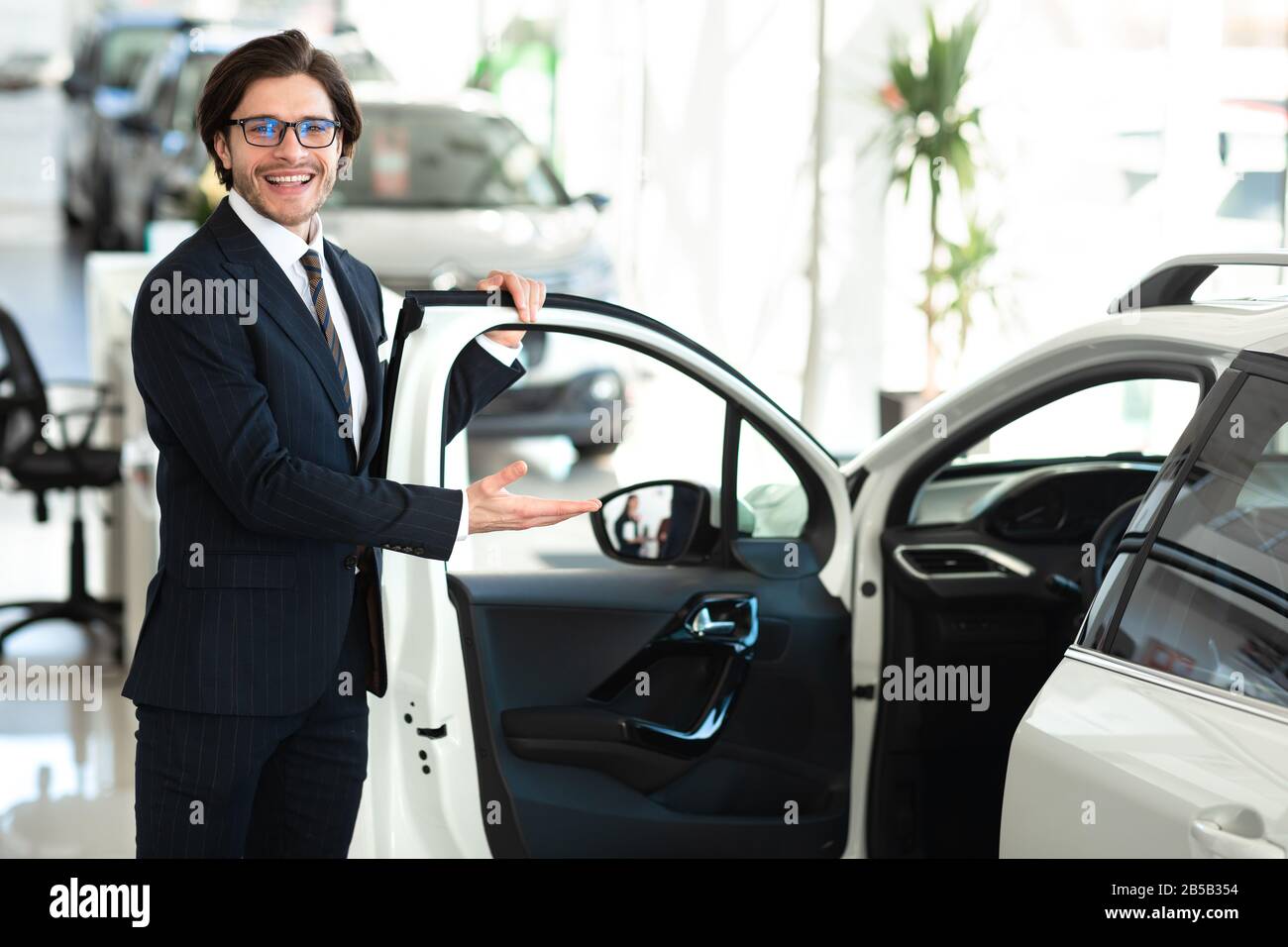 Dealer Showing New Automobile Opening Door In Dealership Center Stock ...
