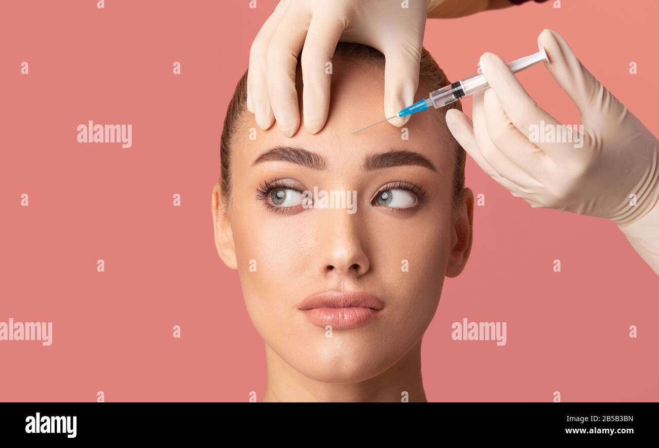 Young Woman Receiving Botox Beauty Injection In Forehead, Studio Shot ...