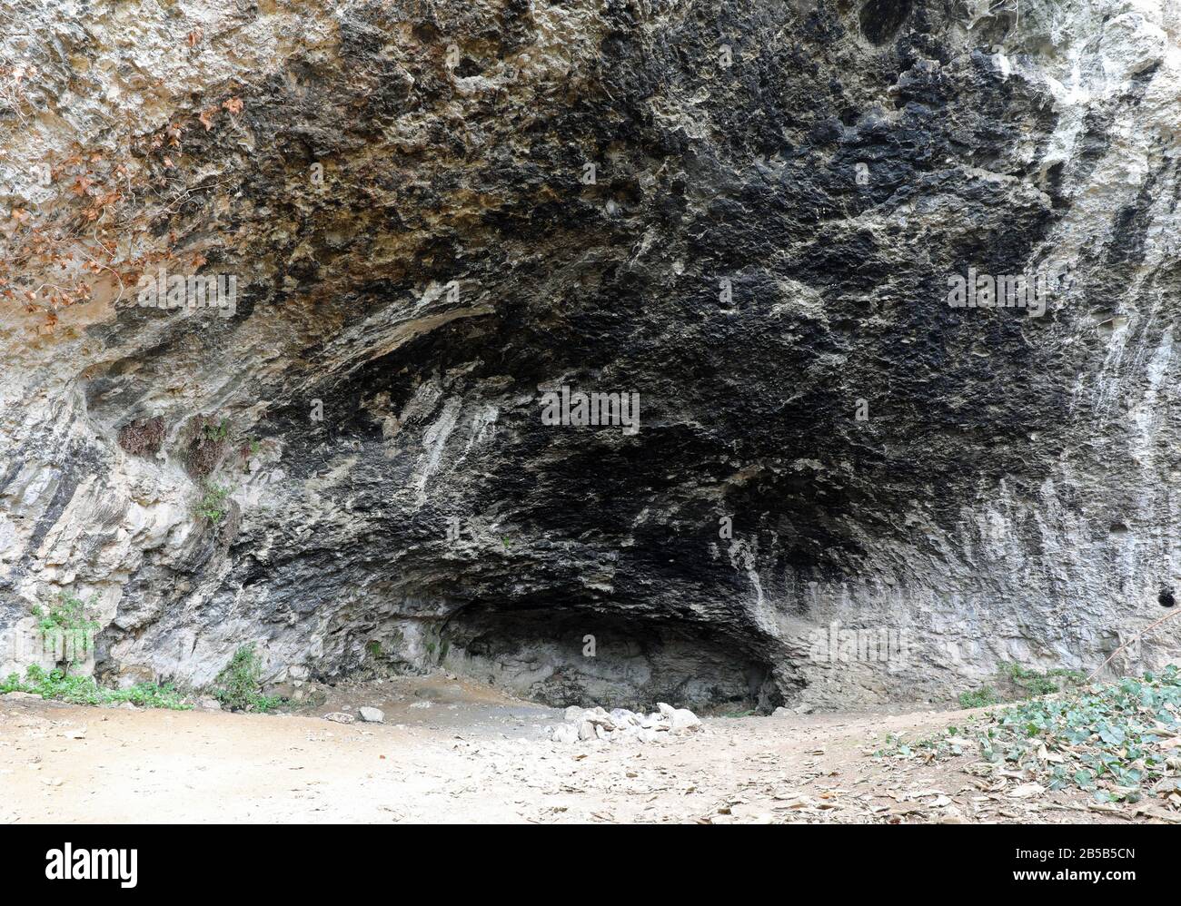 large cave in the rock used by primitive men as a shelter during the ...