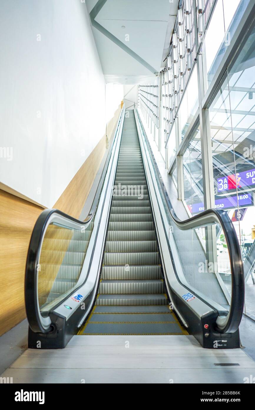 very long escalator beside the glass to outdoor side Stock Photo - Alamy