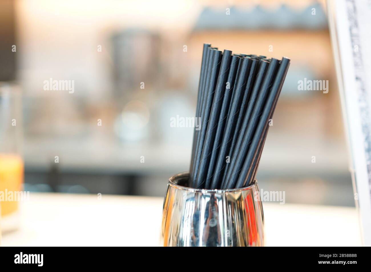 Black paper straw in the stainless cup at the restaurant bar. It's the ...